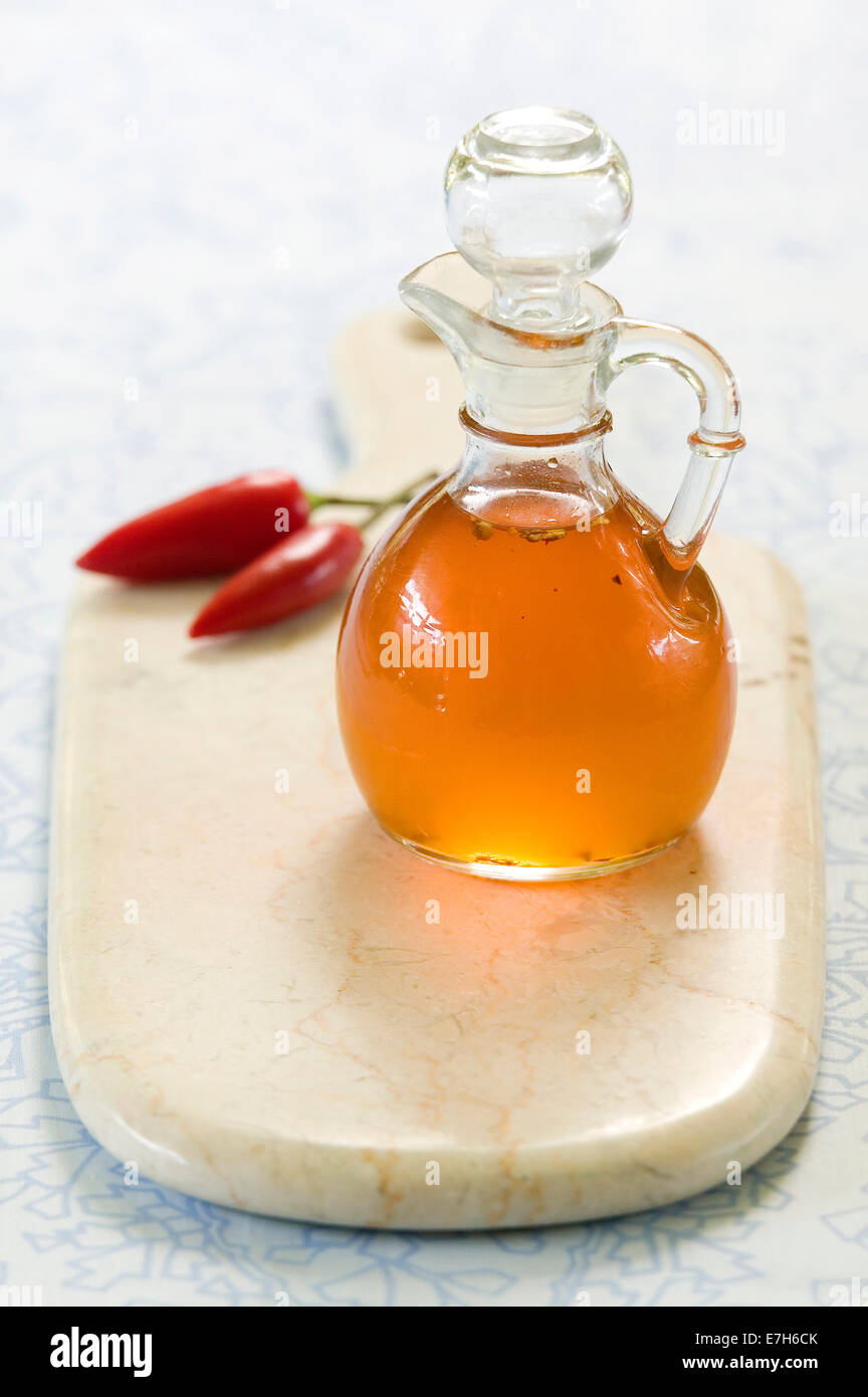 A homemade bottle of chilli oil on a chopping board Stock Photo - Alamy