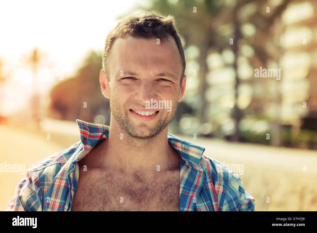 Young smiling Caucasian man outdoor portrait in sunny day Stock Photo ...