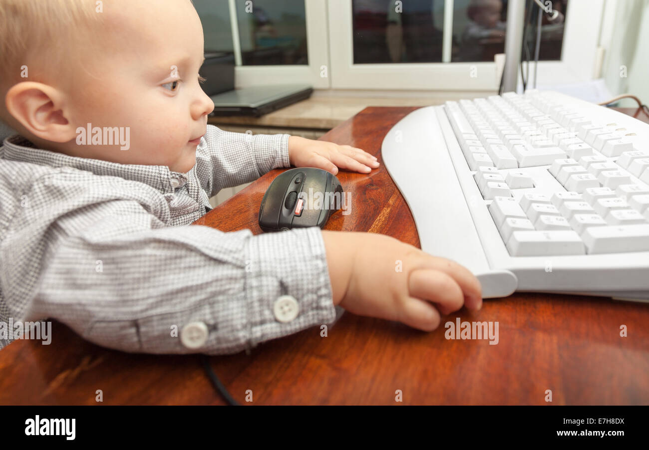 Happy childhood. Smart little boy child kid playing on the desktop ...