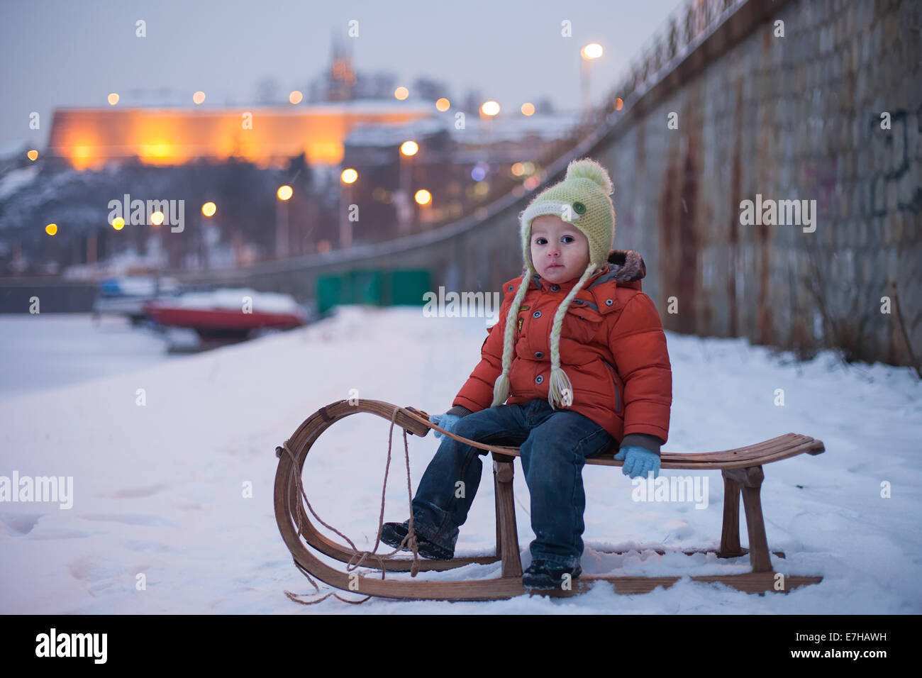 Little boy in the snow on a sledge Stock Photo - Alamy