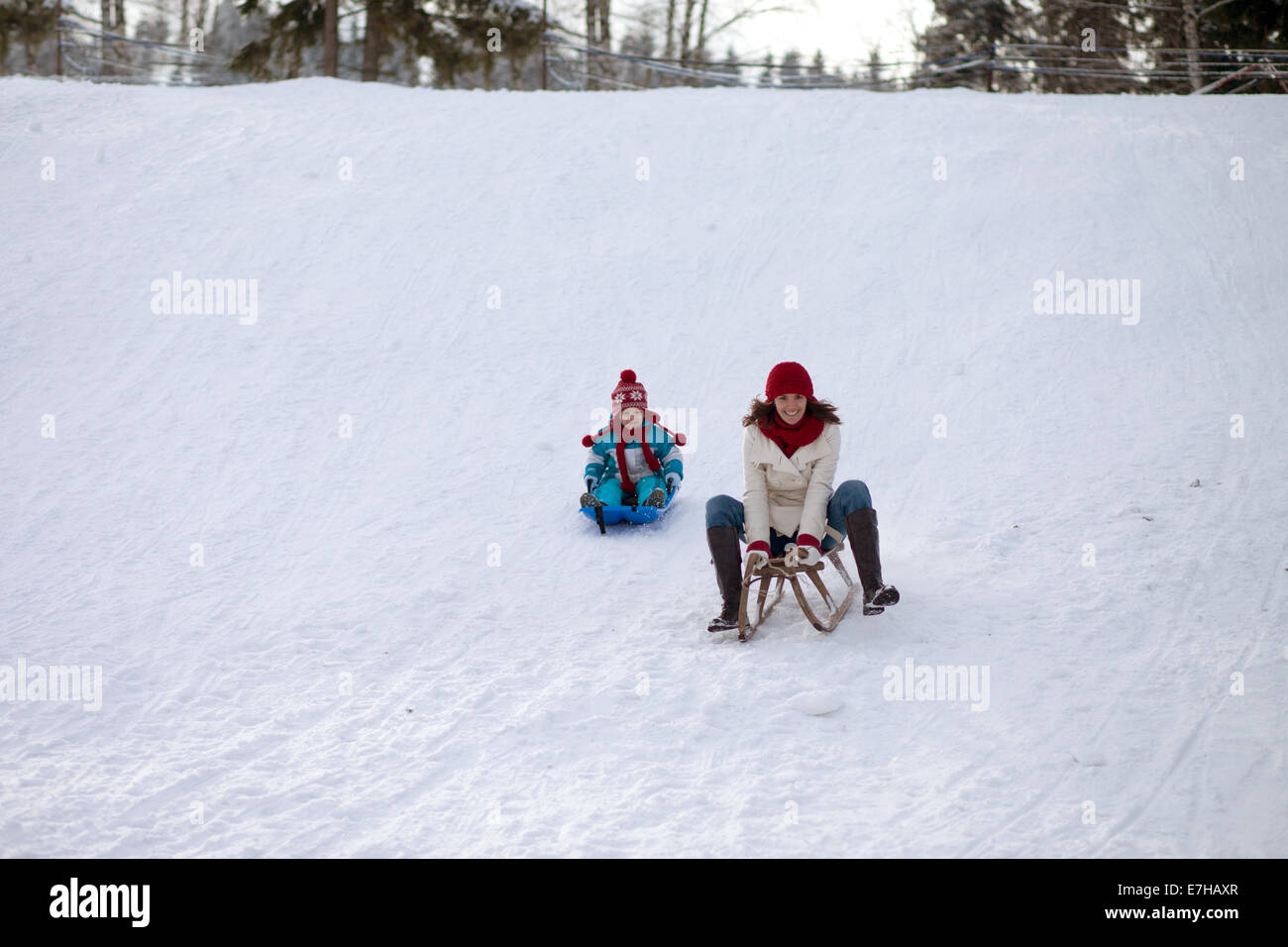 Boy with dad, sitting on a sledge, going down on the hill Stock Photo ...