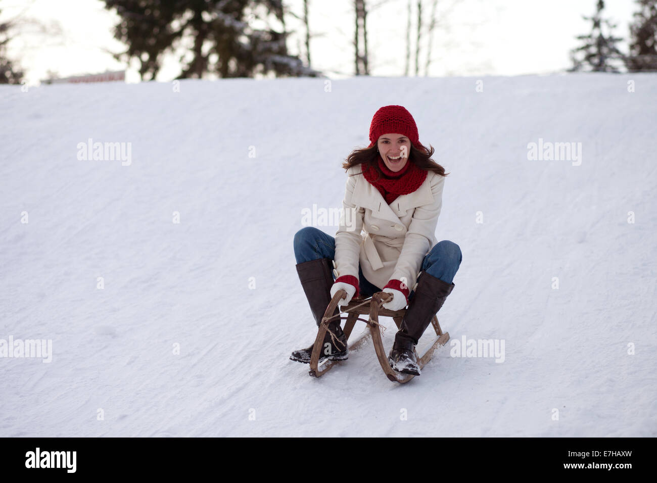Girl, sitting on a sledge, going down on the hill Stock Photo - Alamy