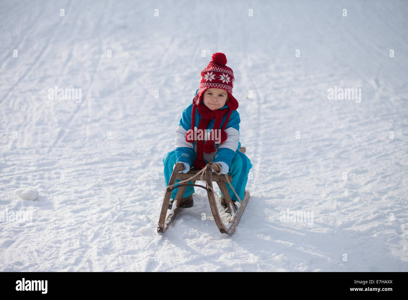 Little boy in the snow on a sledge Stock Photo - Alamy