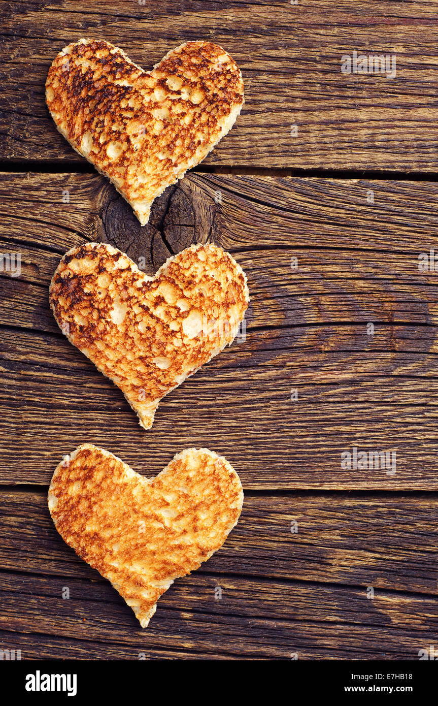 Toast bread in shape of hearts on vintage wooden table Stock Photo - Alamy