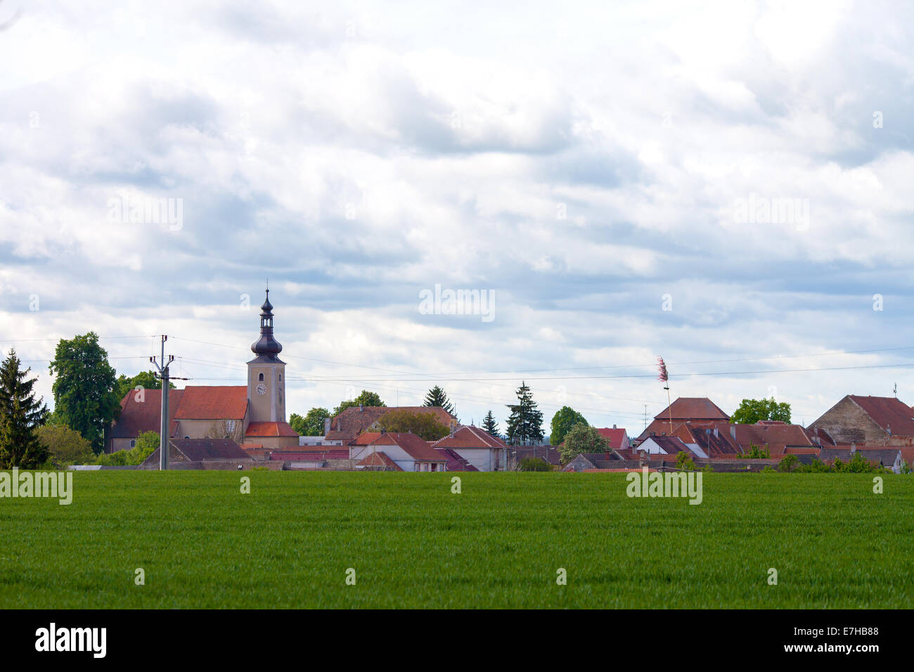Small village and a green field Stock Photo - Alamy