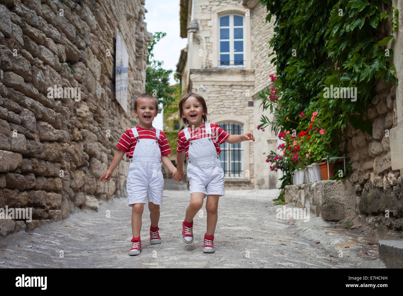 Two adorable kids, walking on the street, laughing Stock Photo - Alamy
