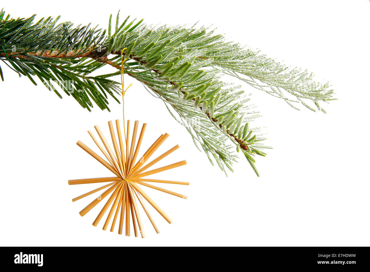 Straw star on a christmas tree with snow in front of a white background ...