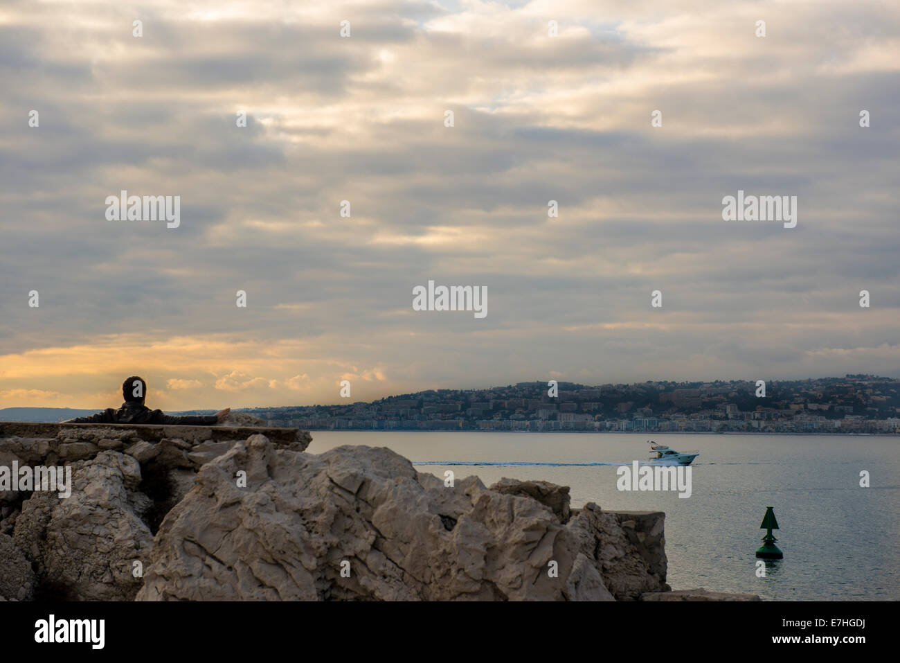 Solitary man watches the sunset over the Baie des Anges in Nice, France ...