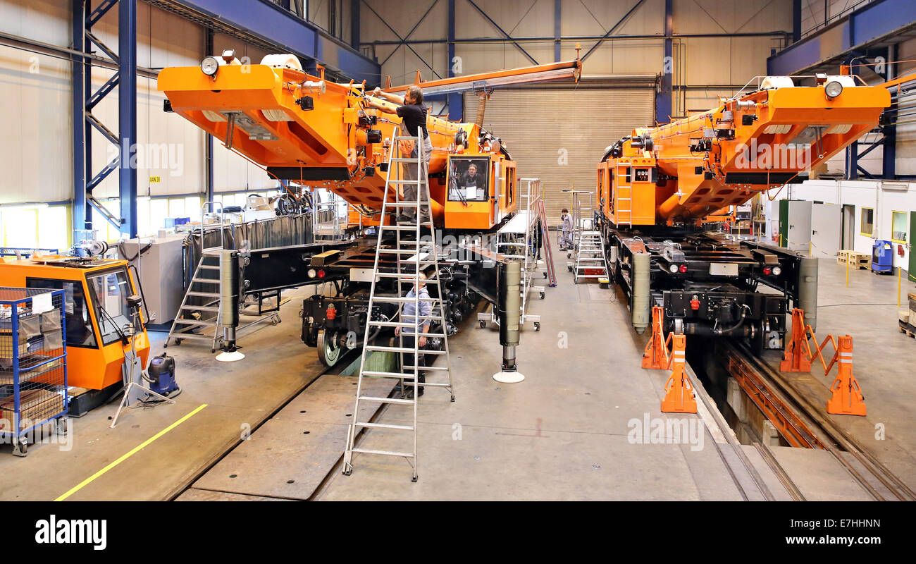 Employees of Kirow Ardelt GmbH work on two railway cranes in Leipzig ...