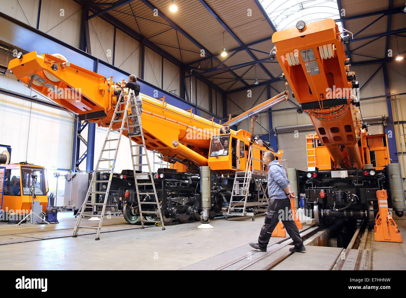 Employees of Kirow Ardelt GmbH work on two railway cranes in Leipzig ...