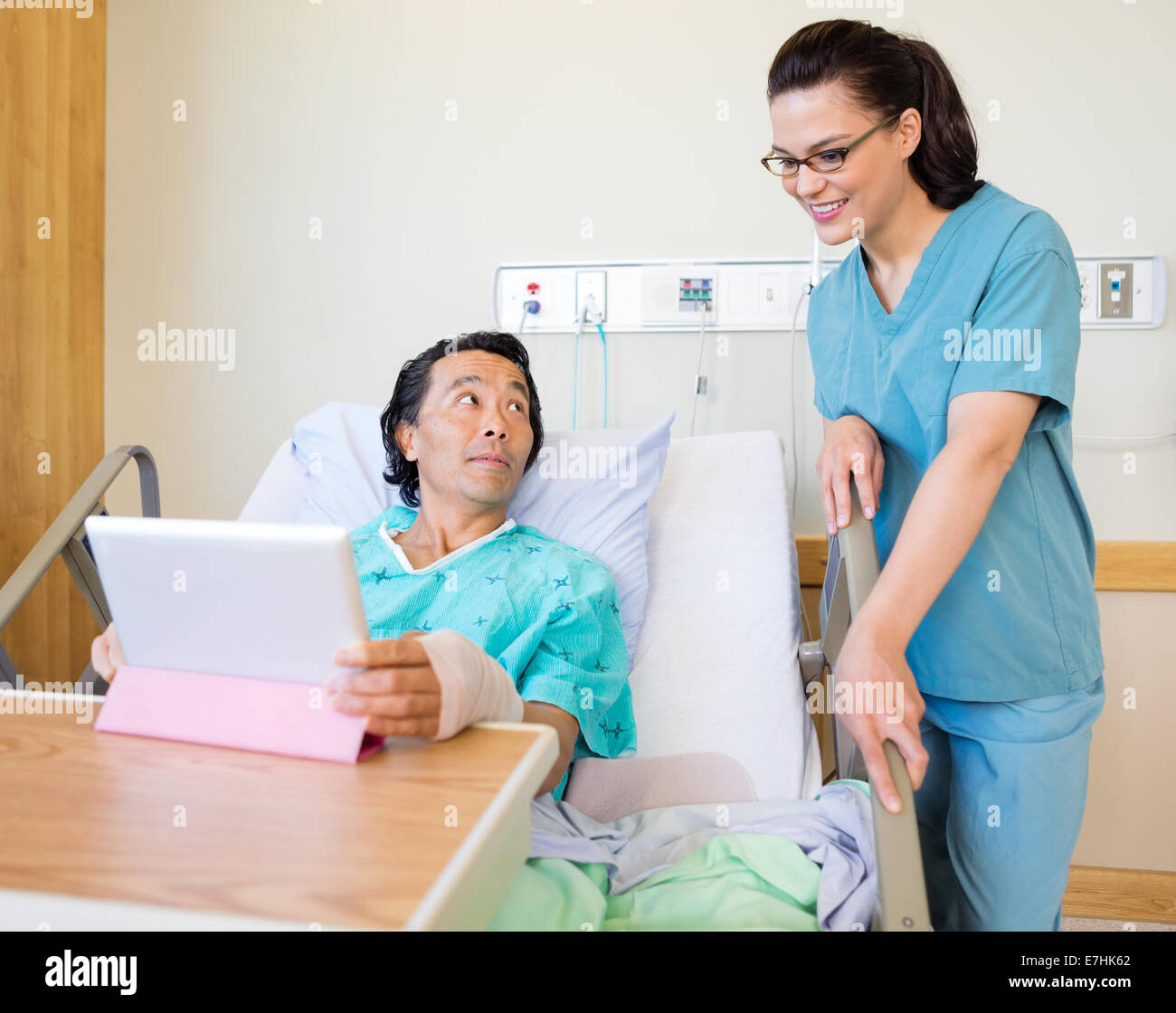 Nurse And Male Patient Using Digital Tablet Stock Photo - Alamy
