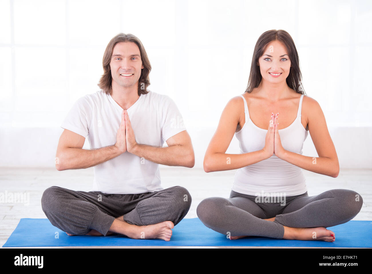 Happy couple in lotus pose Stock Photo - Alamy