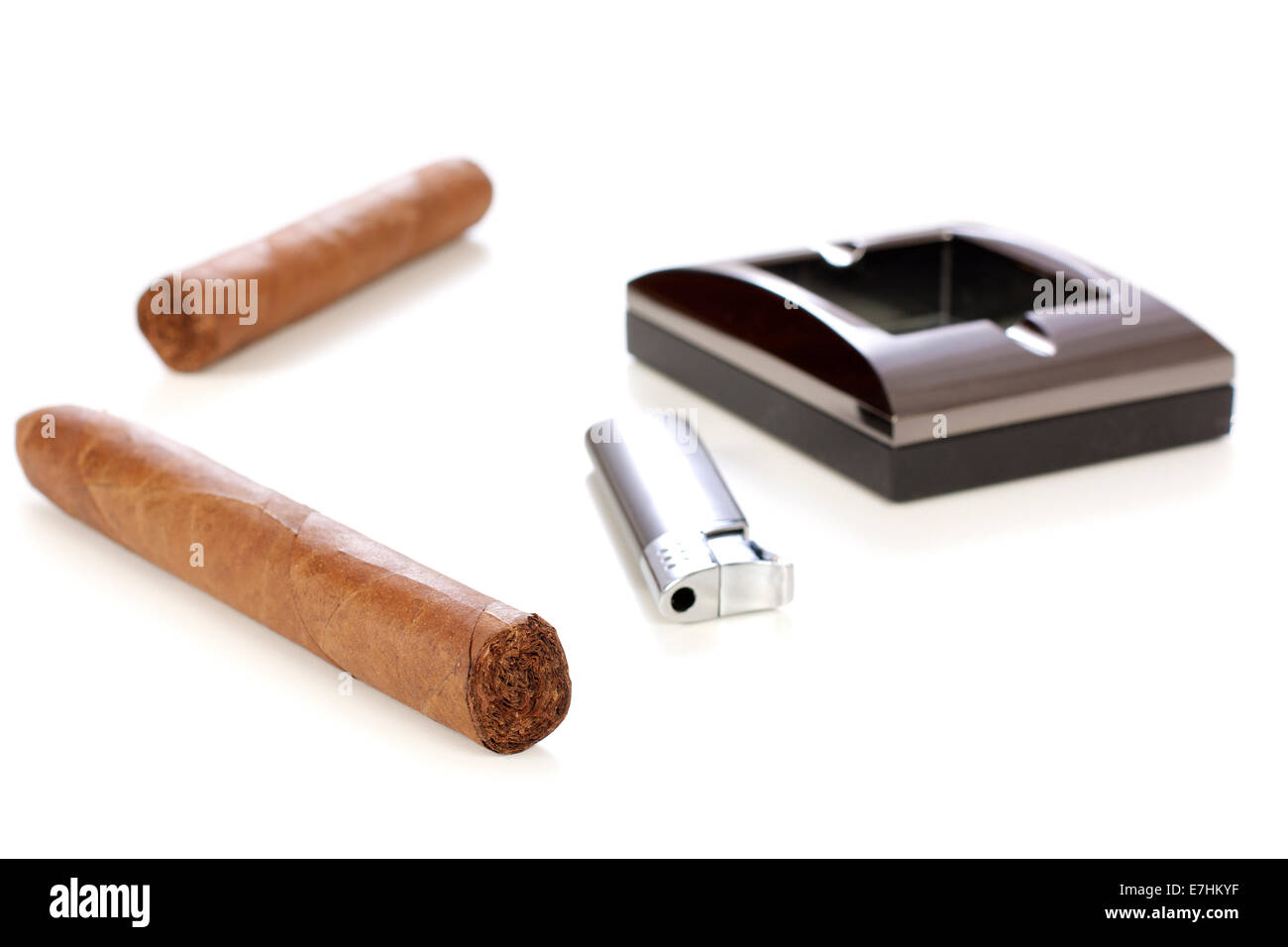 Close up of metallic ashtray, lighter and cuban cigar isolated over ...