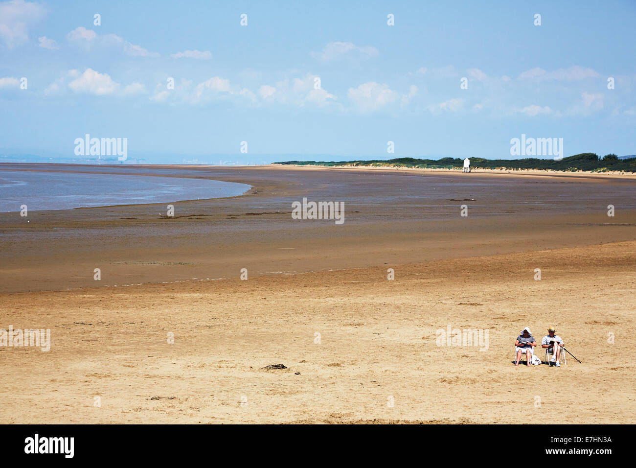 2 people sit on Burnham On Sea Beach, Somerset, England, UK Stock Photo ...