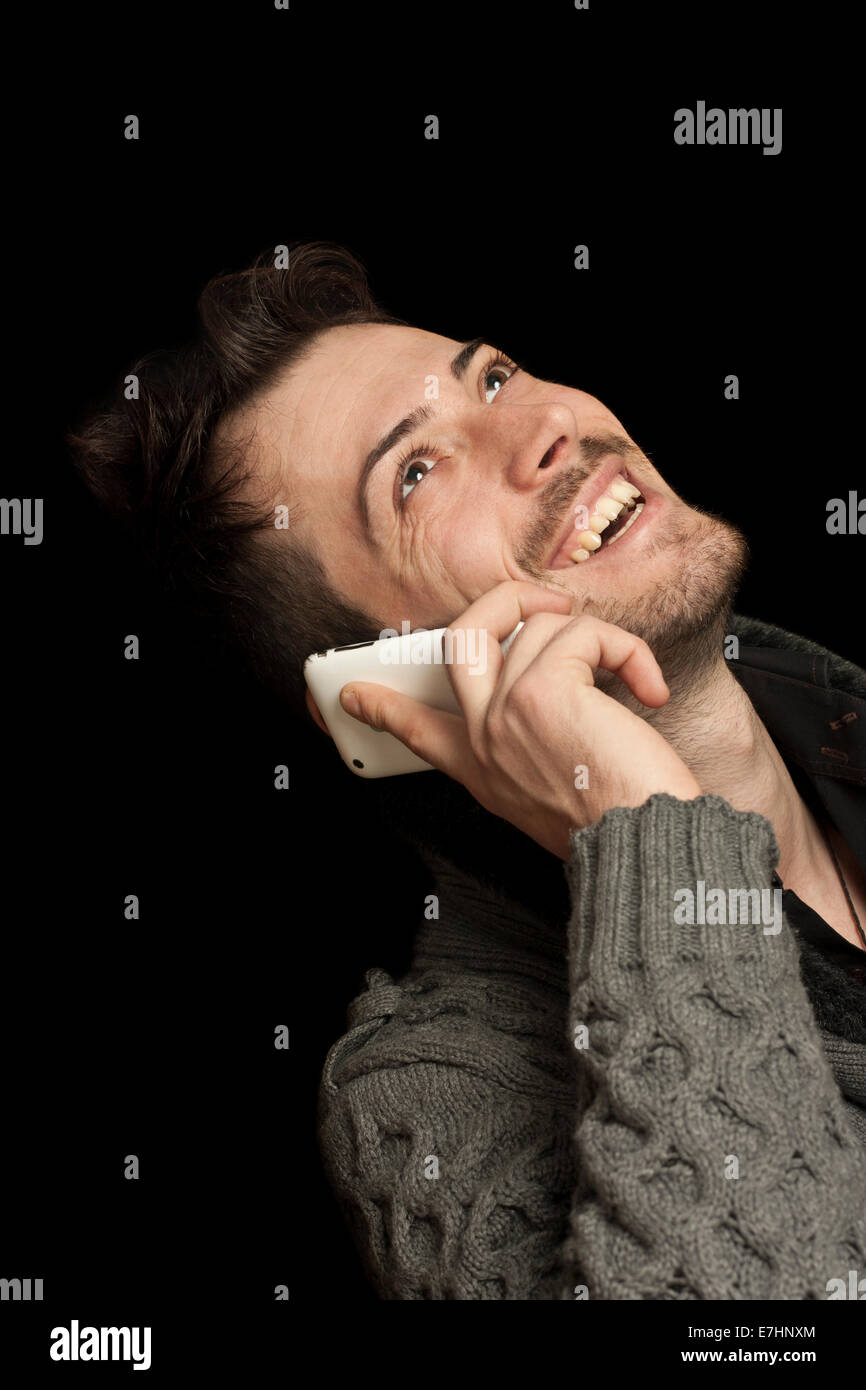 Portrait of casual man talking on mobile phone. Isolated on black Stock ...