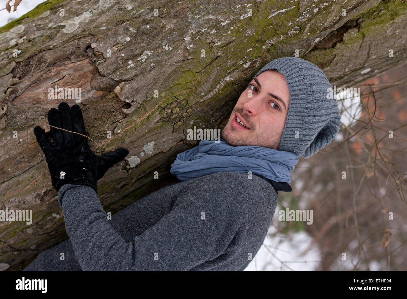 Attractive young man sitting next to a tree Stock Photo - Alamy