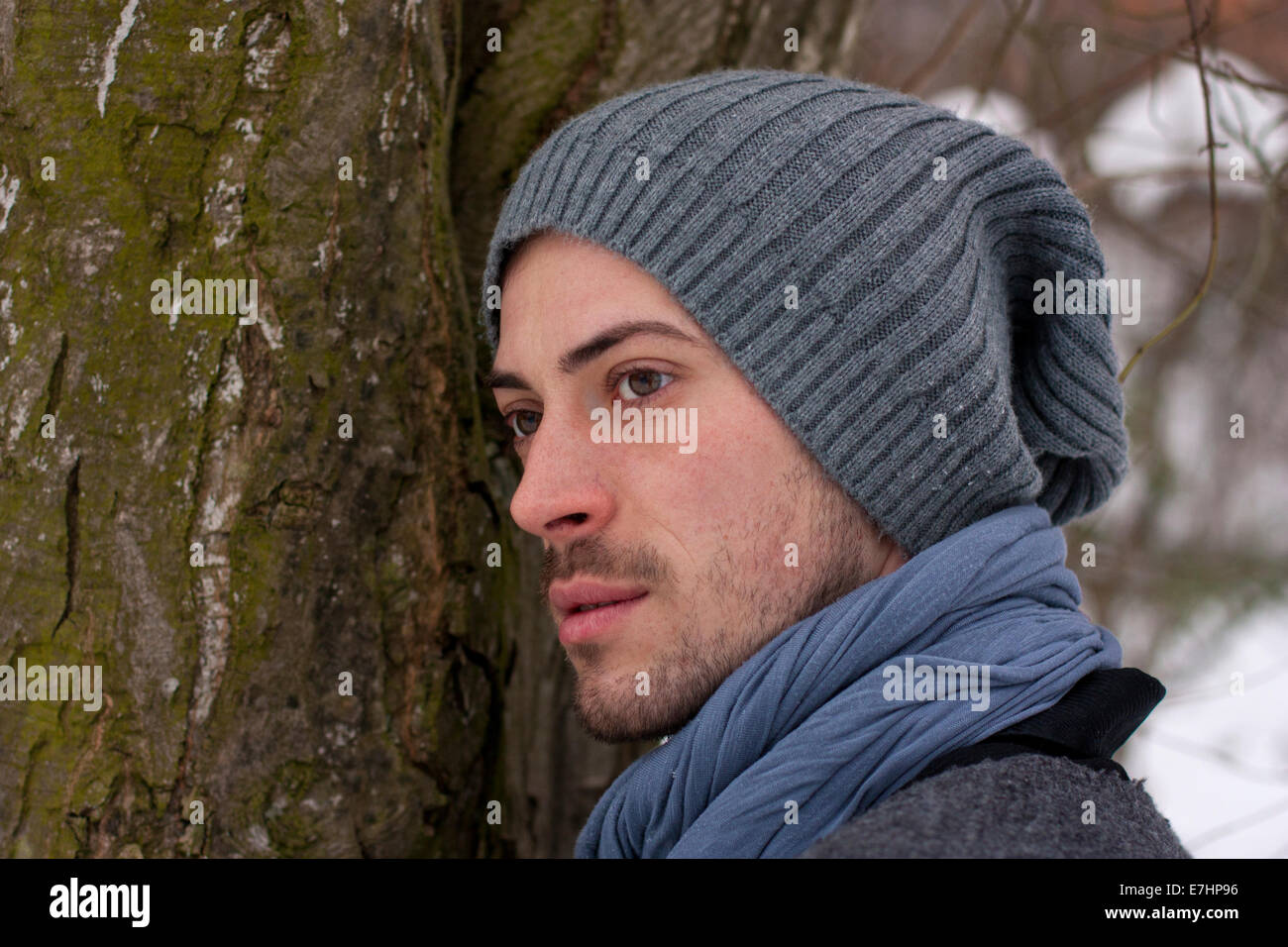 Portrait of attractive young man sitting next to a tree Stock Photo - Alamy
