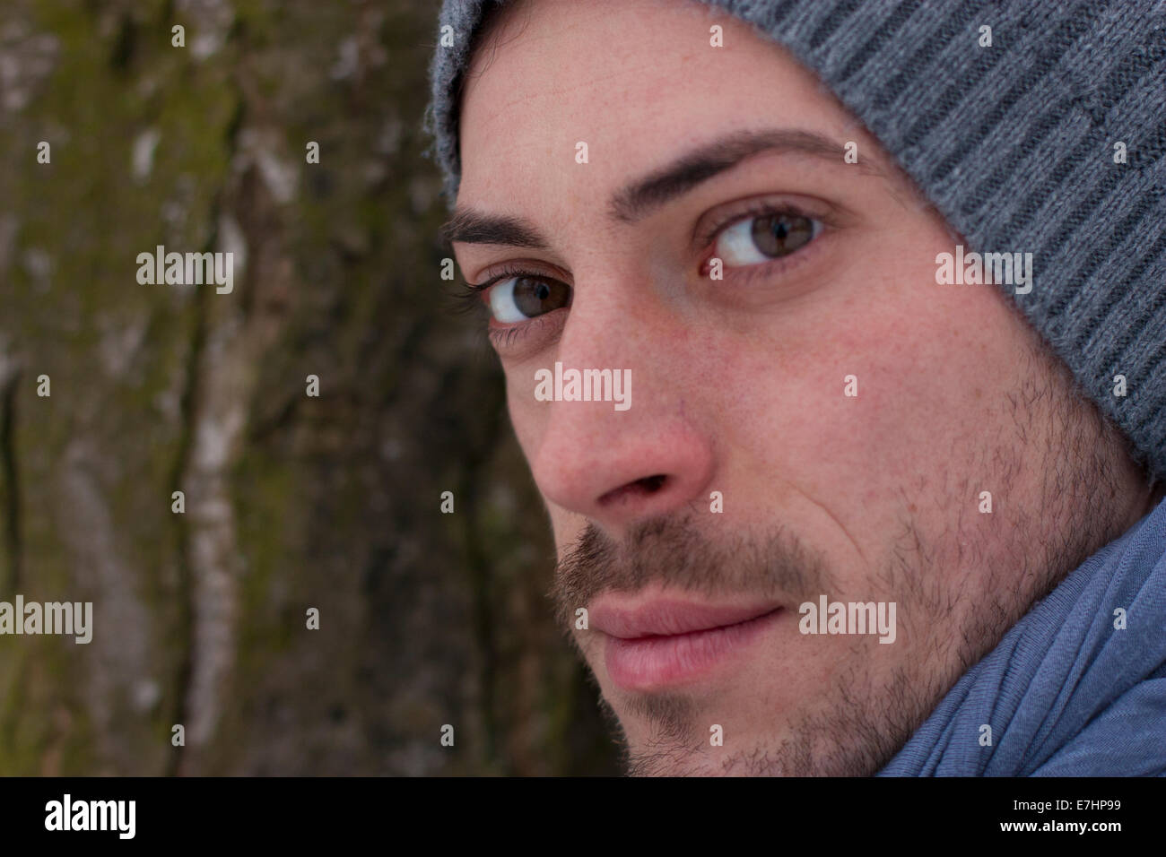Portrait of attractive young man sitting next to a tree Stock Photo - Alamy