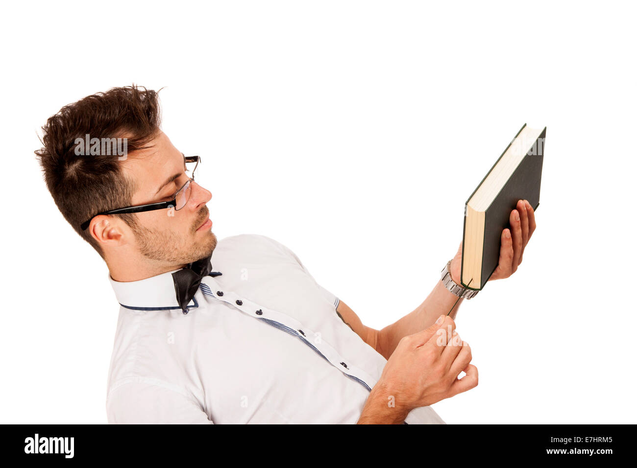 Young man holding a book and thinking isolated over white background ...