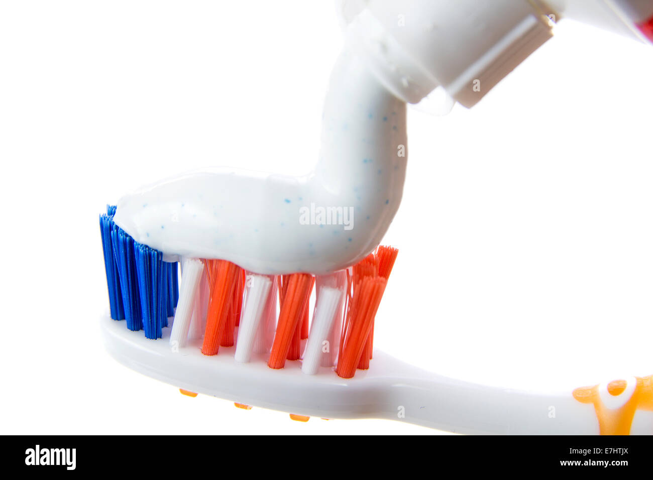 Squeezing toothpaste onto toothbrush isolated over white background ...