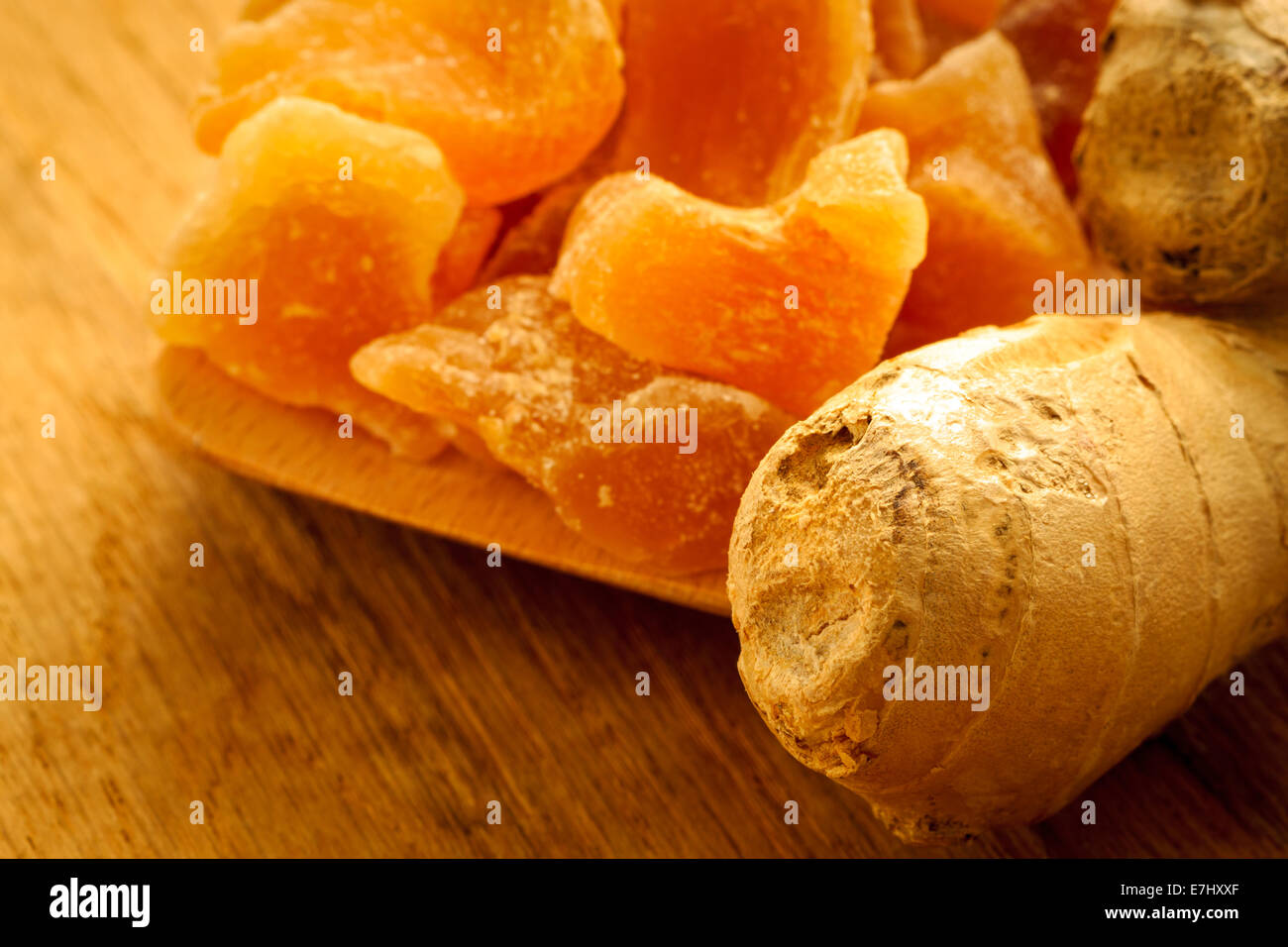 Closeup dried candied crystallized ginger pieces and fresh root on ...