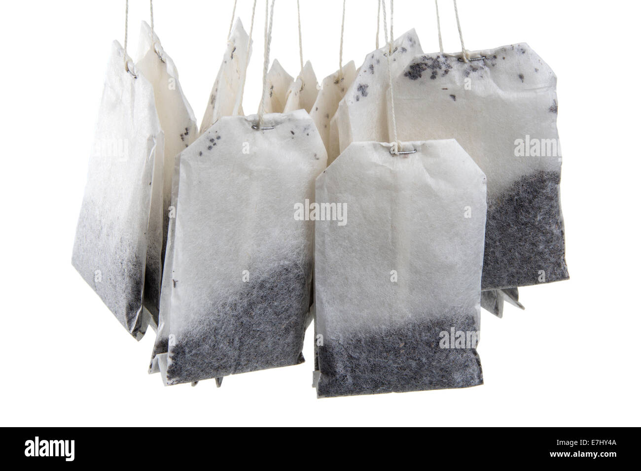 Hanging tea bags in a close-up image isolated over white background ...