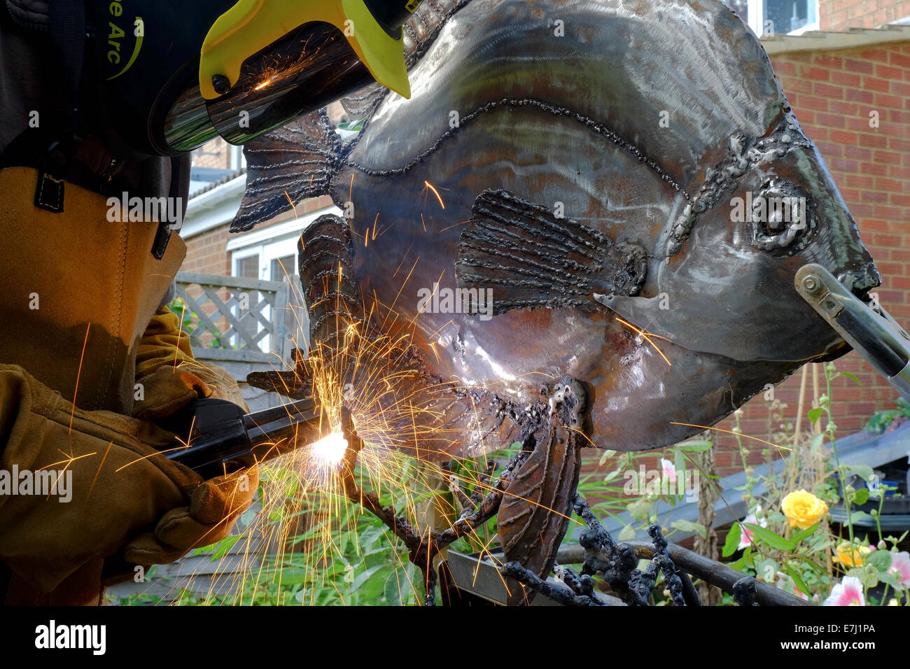 Sculptor stick welding a metal fish Stock Photo - Alamy
