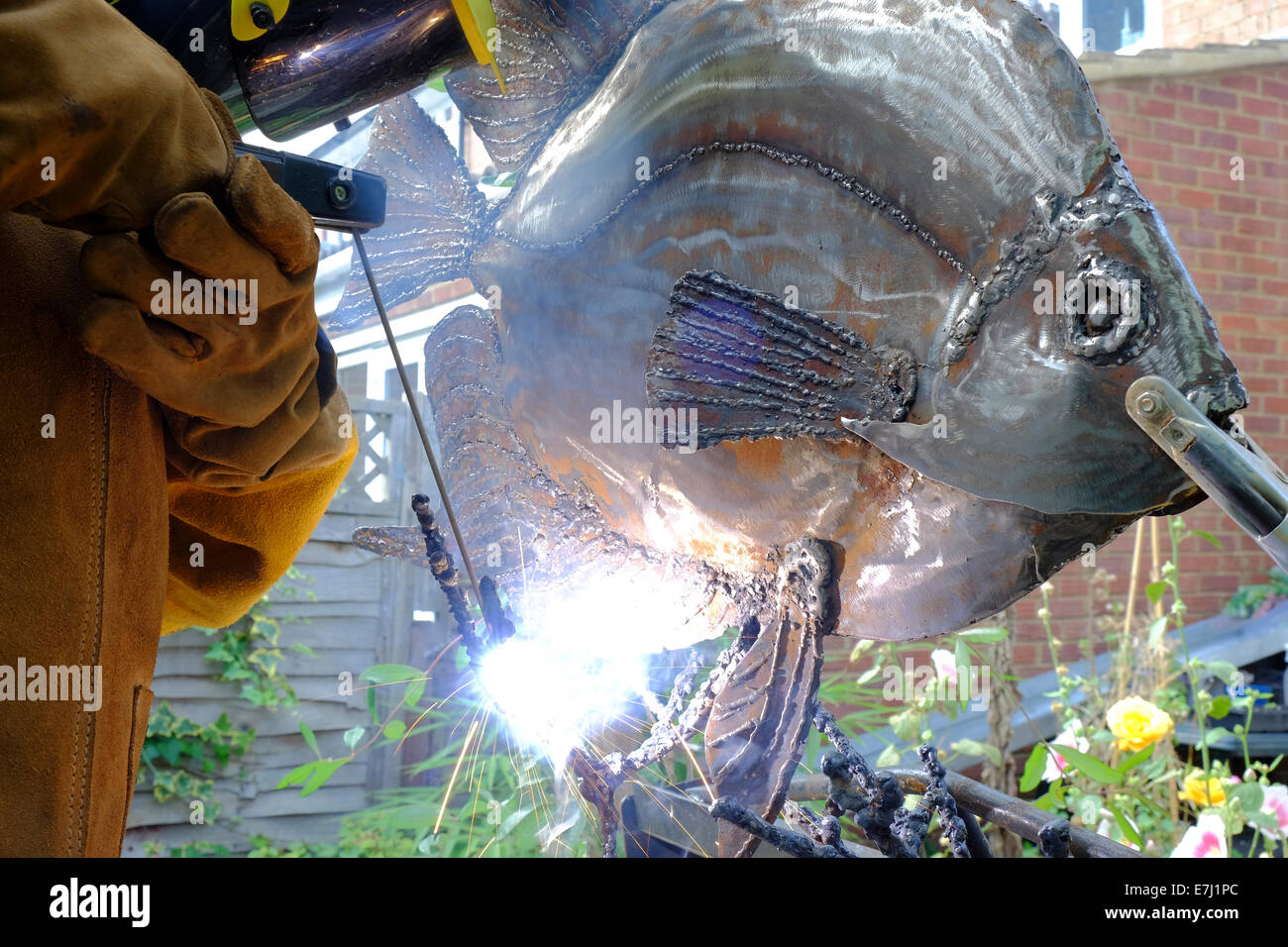 Sculptor stick welding a metal fish Stock Photo - Alamy