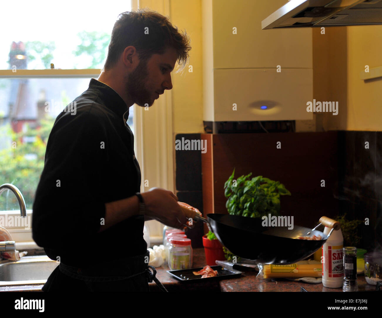 Young chef cooking a carbonara on the stove in a kitchen Stock Photo ...