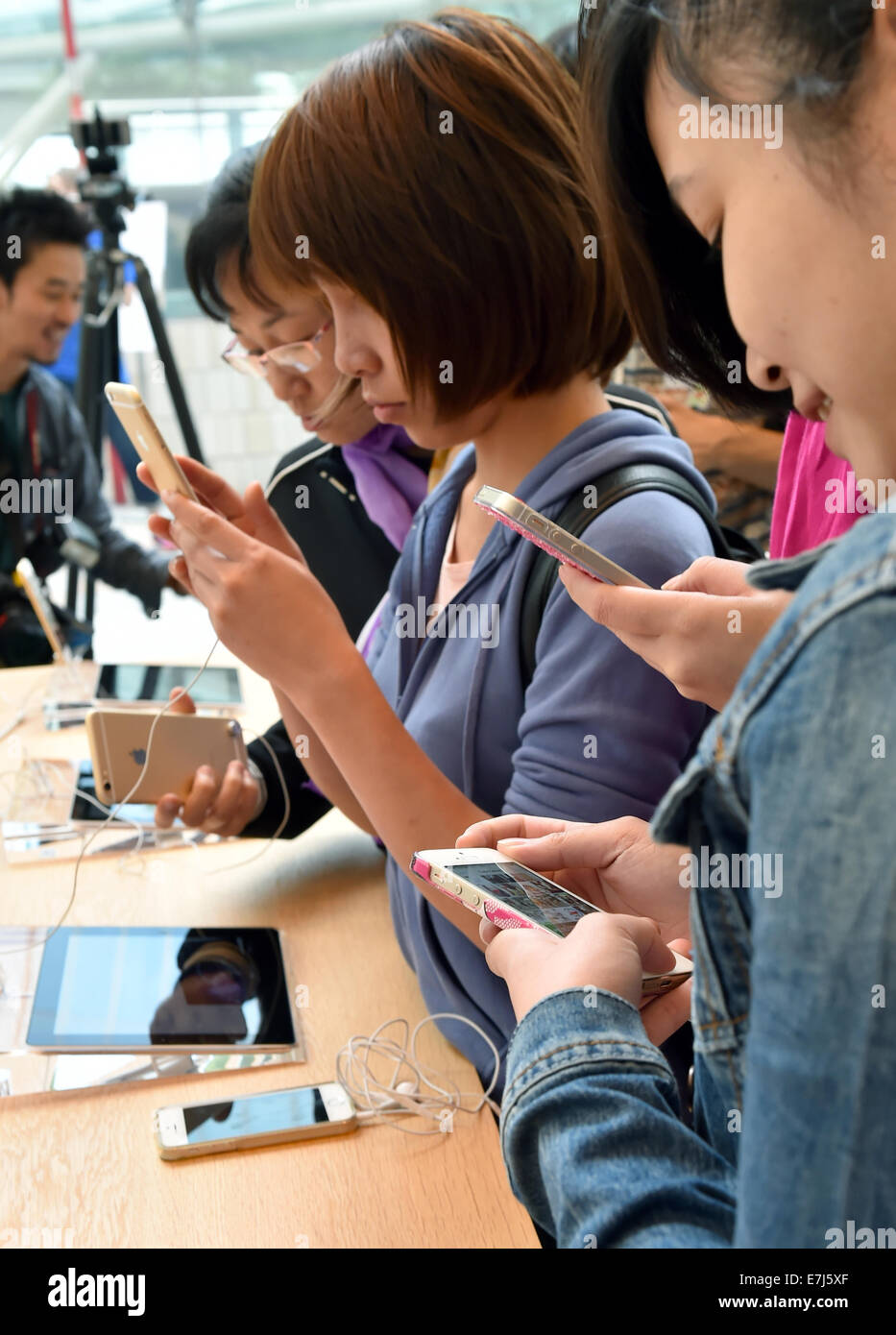 Tokyo, Japan. 19th Sept, 2014. Visitors try their hands on Apple's new ...