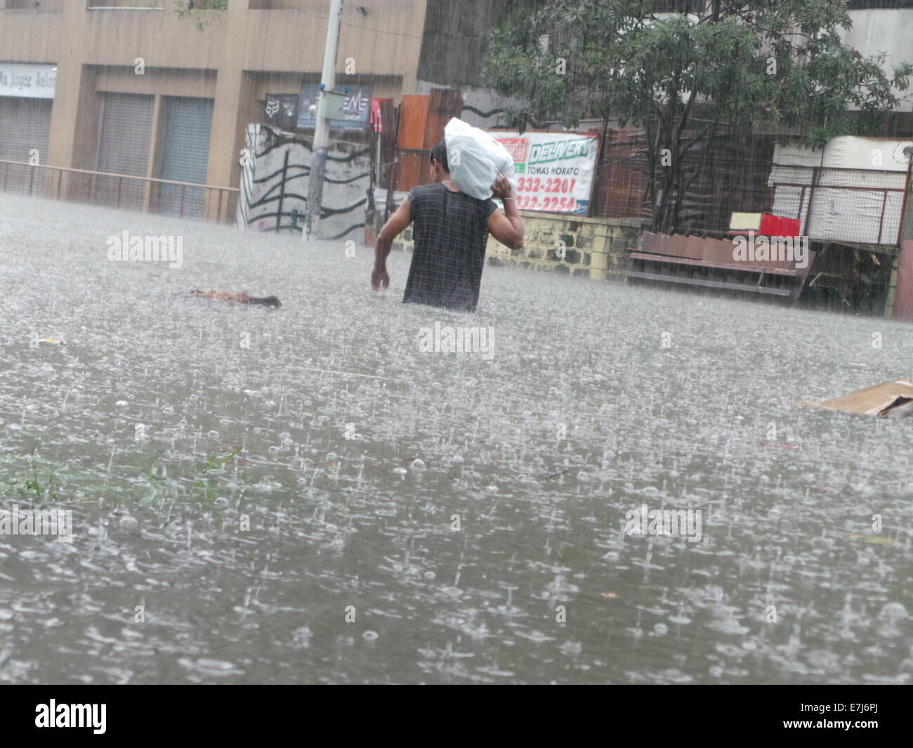Men passing thru flooded Panay Avenue in Quezon City as Typhoon Mario ...