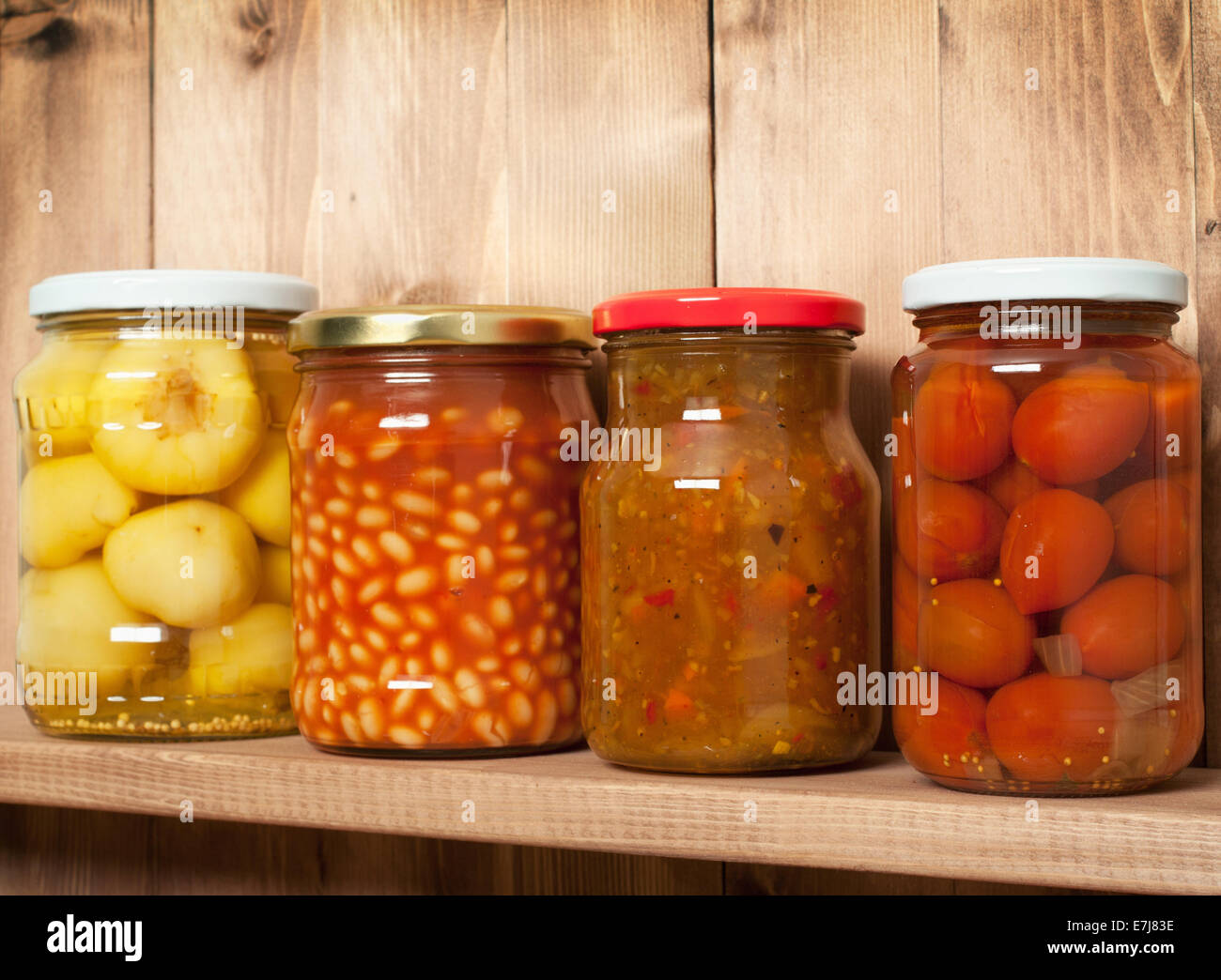 Preserved vegetable on shelf near a brown wooden wall Stock Photo - Alamy