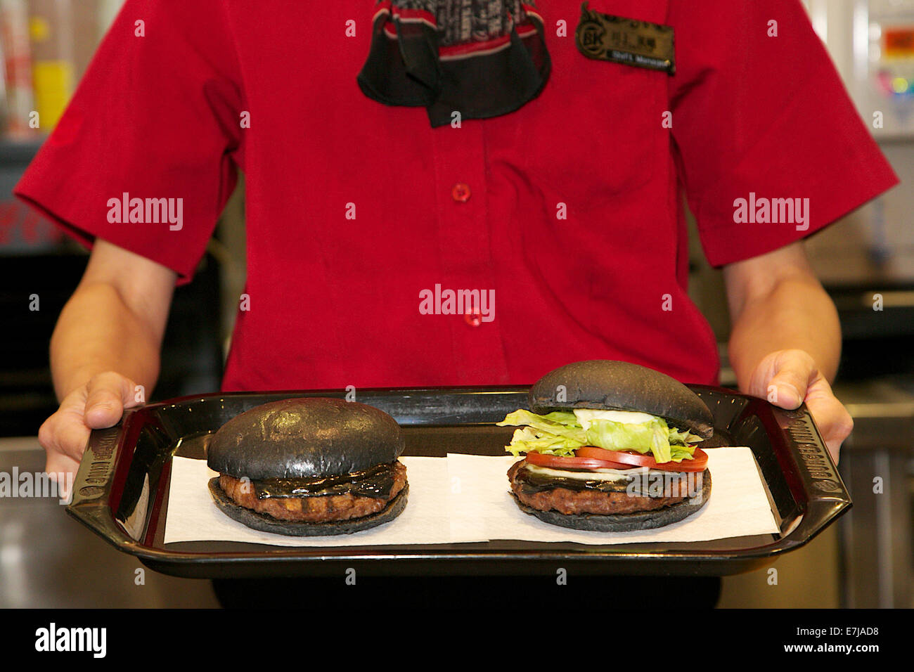 Tokyo, Japan. 19th Sep, 2014. A woman shows two kinds of "kuro burger ...