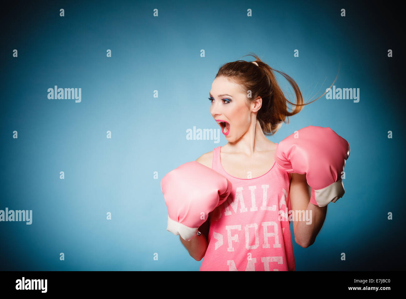 Funny girl female boxer in big fun pink gloves playing sports boxing ...