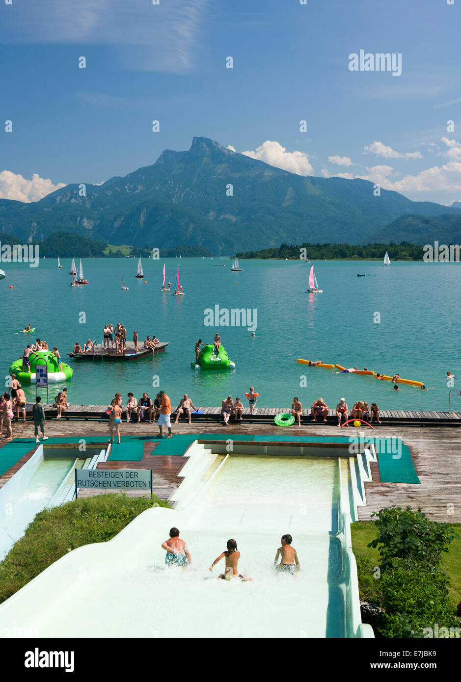 Alpine lakeside pool, water slide, Schafberg Mountain, Mondsee lake ...