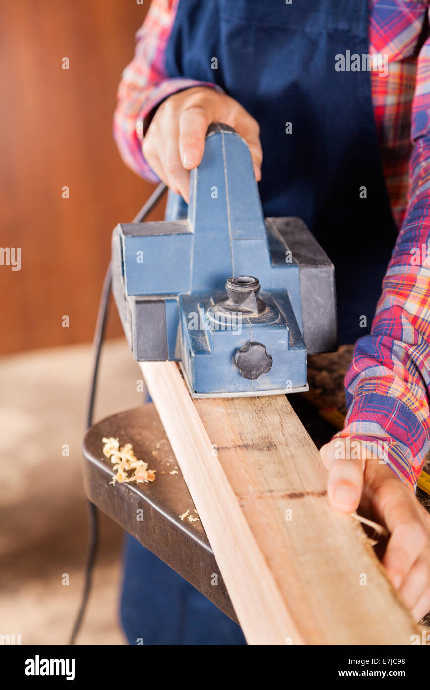 Carpenter Using Electric Planer On Wood Stock Photo - Alamy