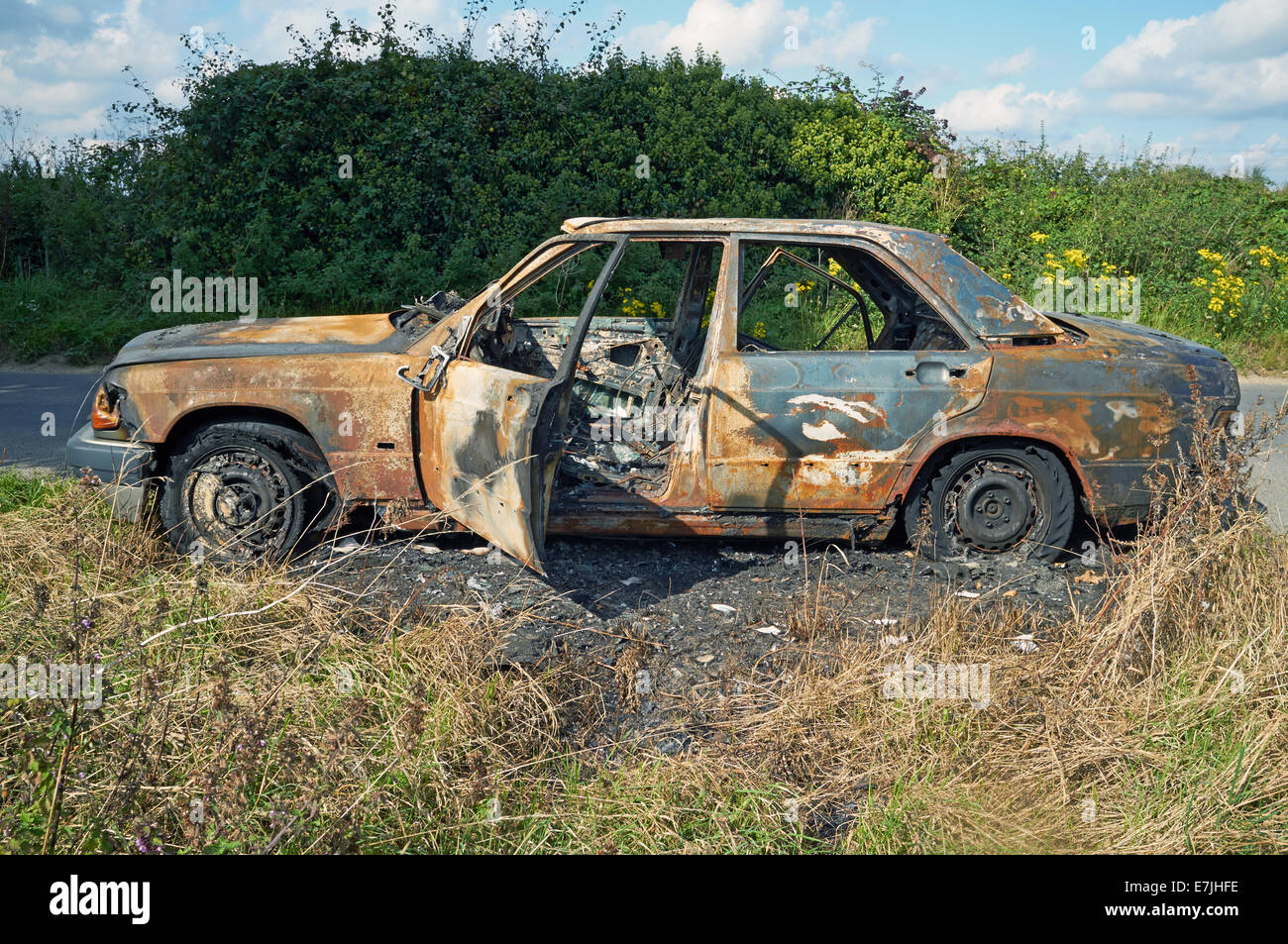 Burnt out car beside the road Stock Photo - Alamy