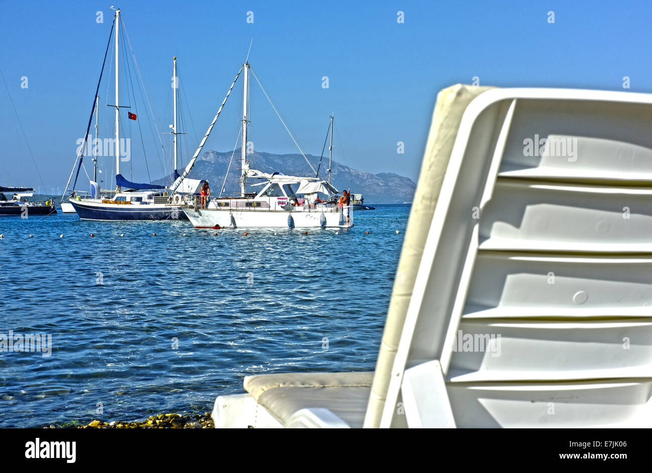 Empty beach bed and yachts in Turkey Stock Photo - Alamy