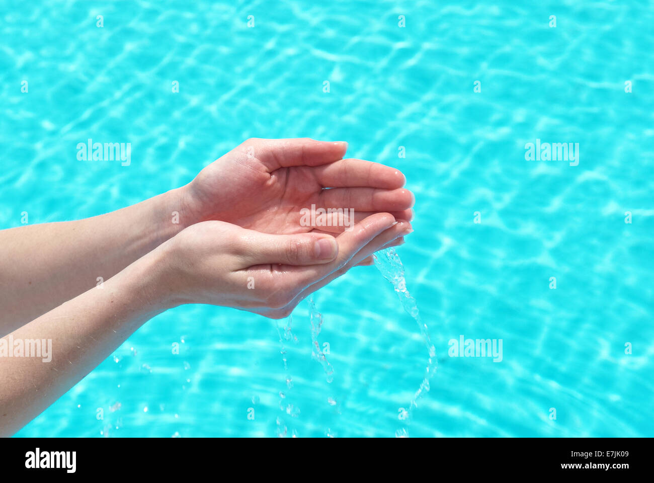 Human hands with clear water on the blue background Stock Photo - Alamy