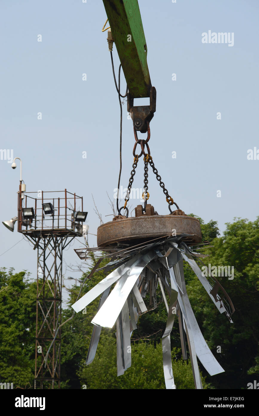 magnetic grab on crane lifting metal at scrapyard uk Stock Photo - Alamy