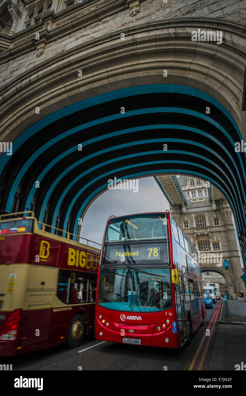 A tour bus and regular bus pass through one of the gates of Tower ...