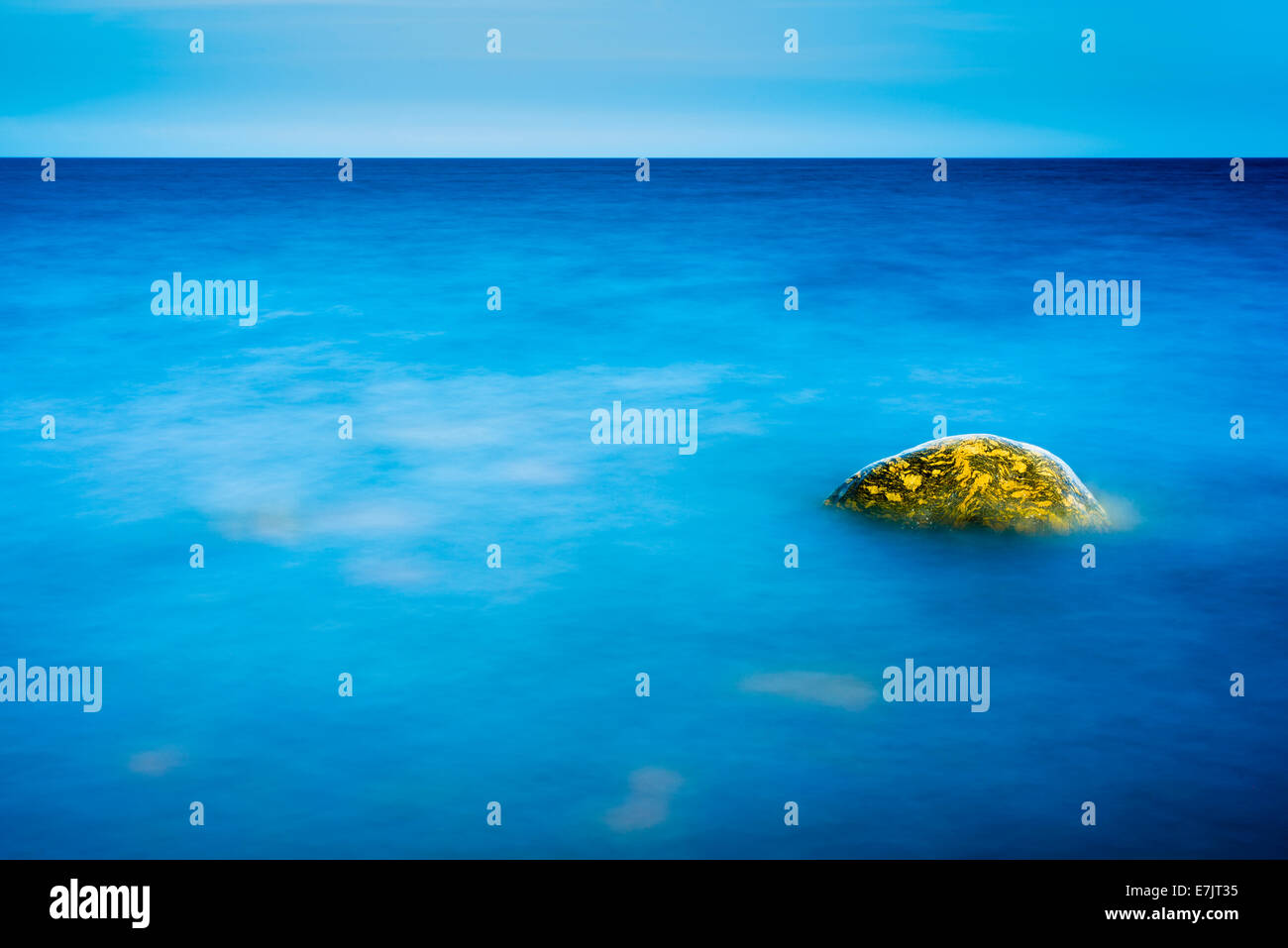 Alone stone in the blue sea Stock Photo - Alamy