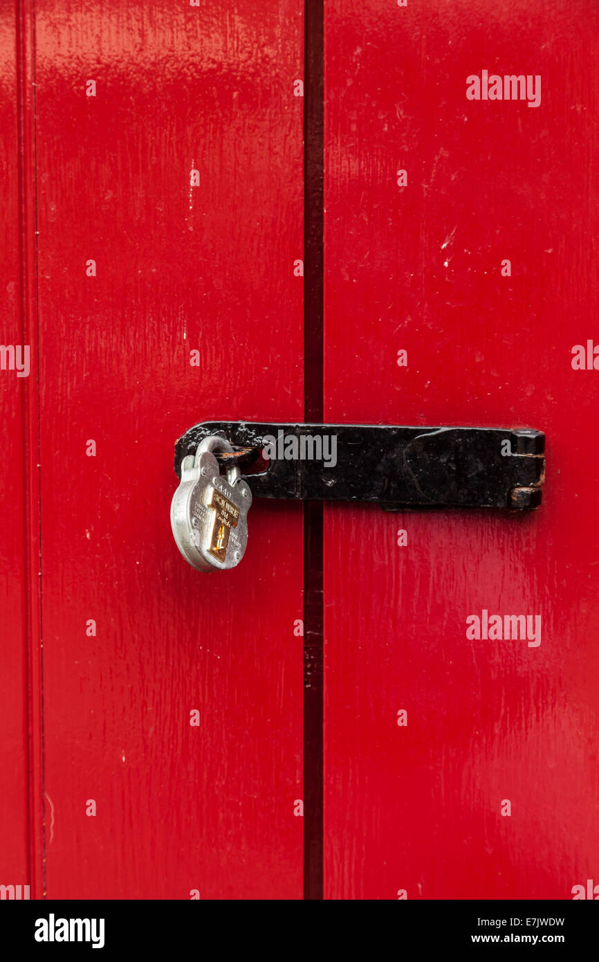 Bright Red Door locked up with squire lock Stock Photo - Alamy