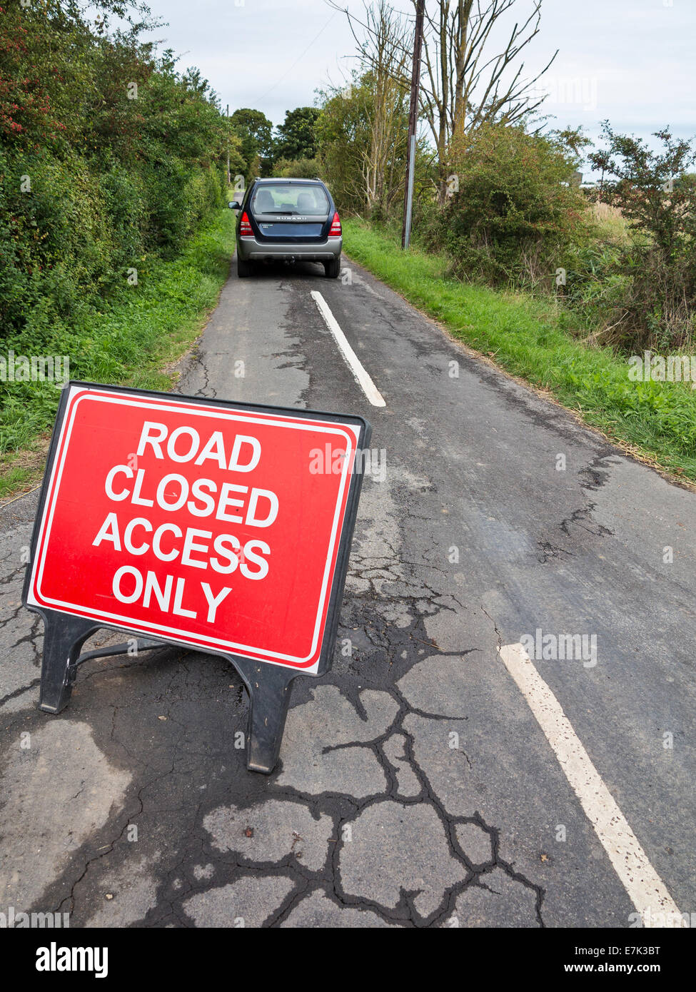 A driver ignores a closed road sign and drives down a road in the ...