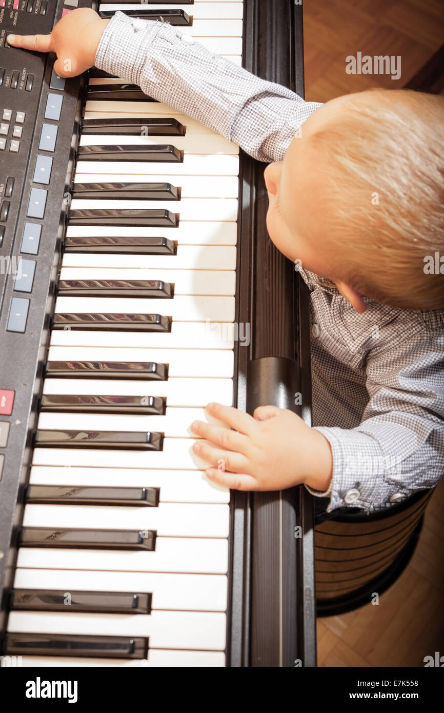 Happy childhood and music. Little boy child kid playing on the black ...