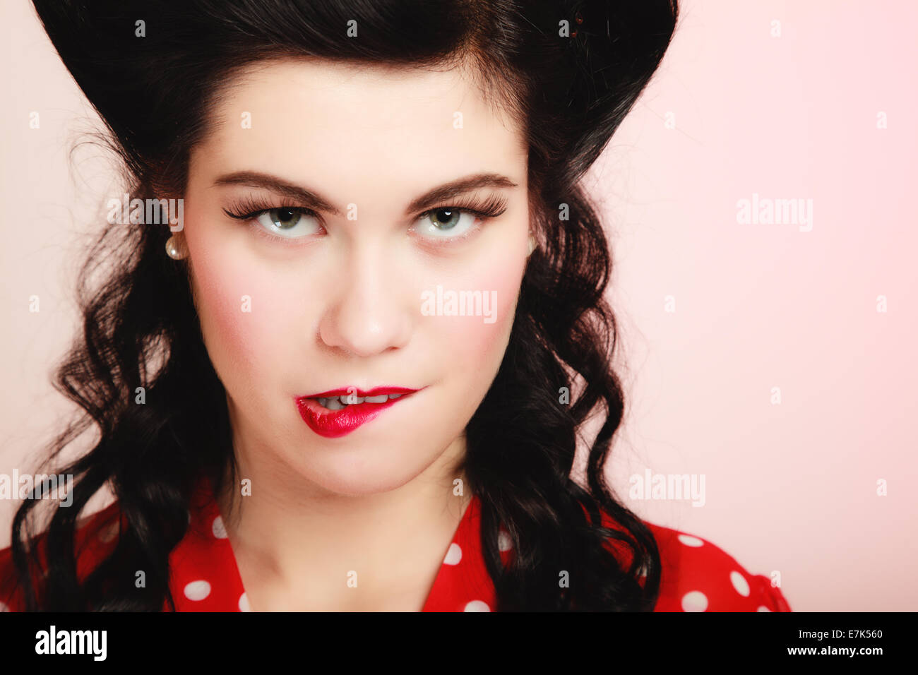 Retro style. Portrait of stylish woman biting her lips on pink ...
