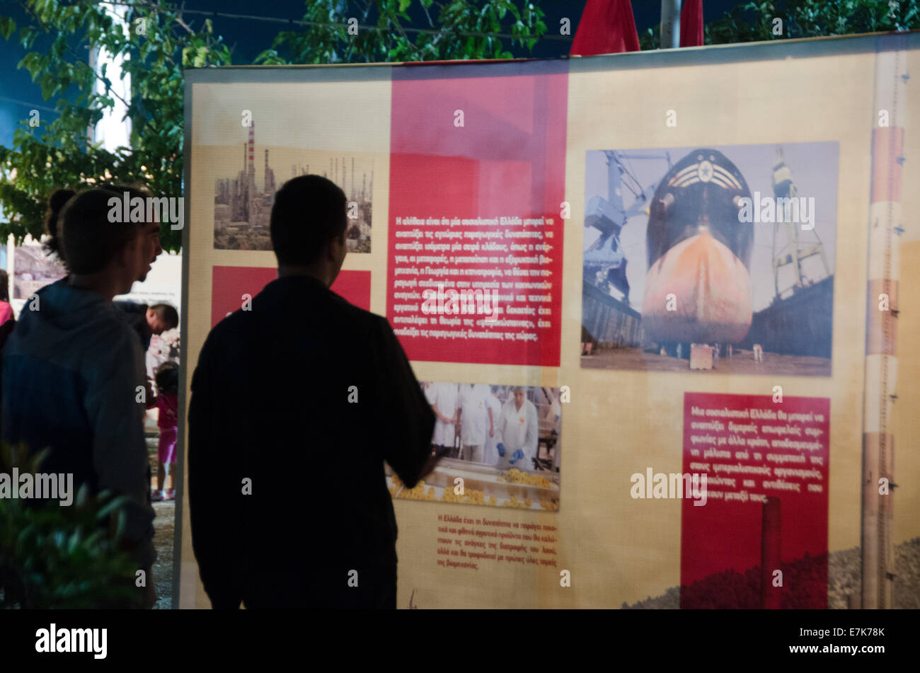 Visitors of the festival read giant posters that depict KKE and KNE ...