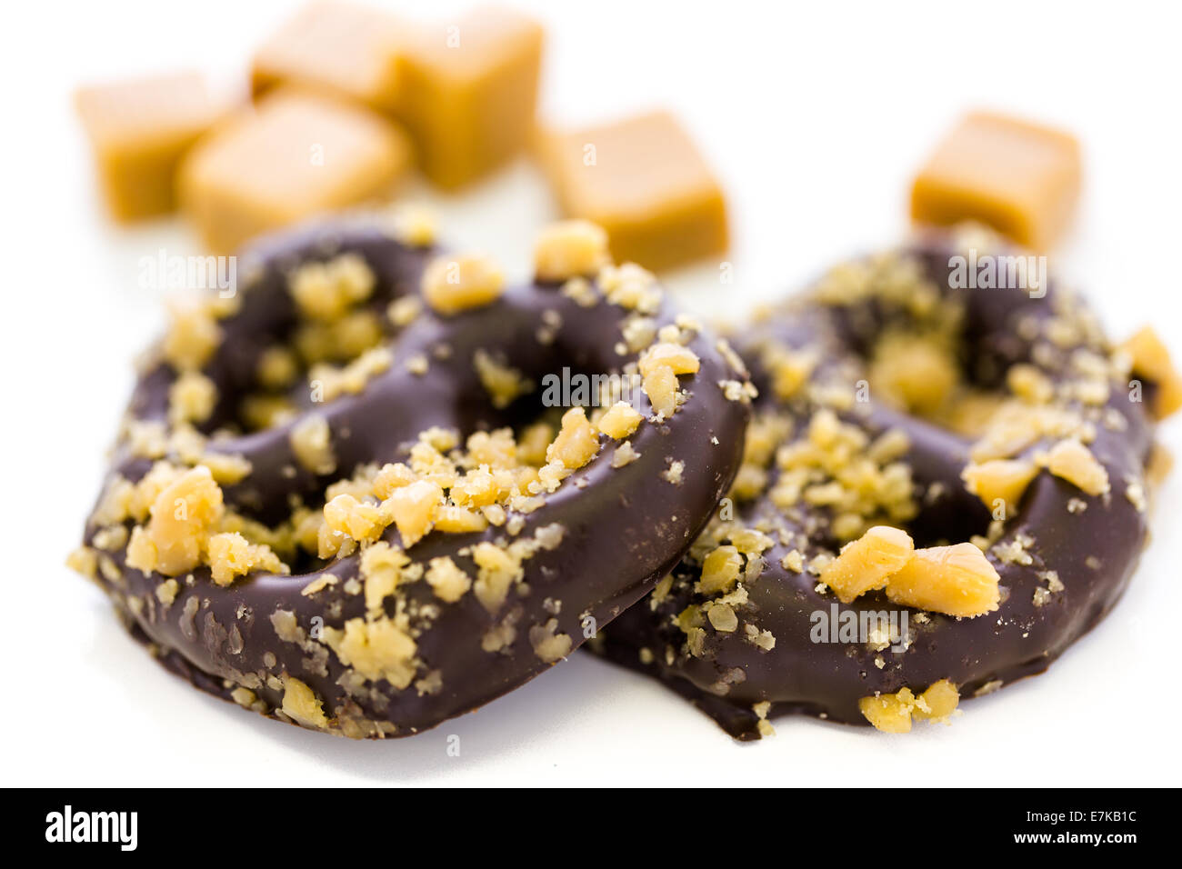 Gourmet chocolate covered pretzel with caramel chunks on a white ...