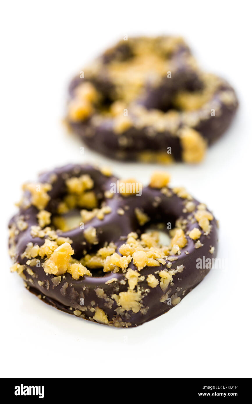 Gourmet chocolate covered pretzel with caramel chunks on a white ...