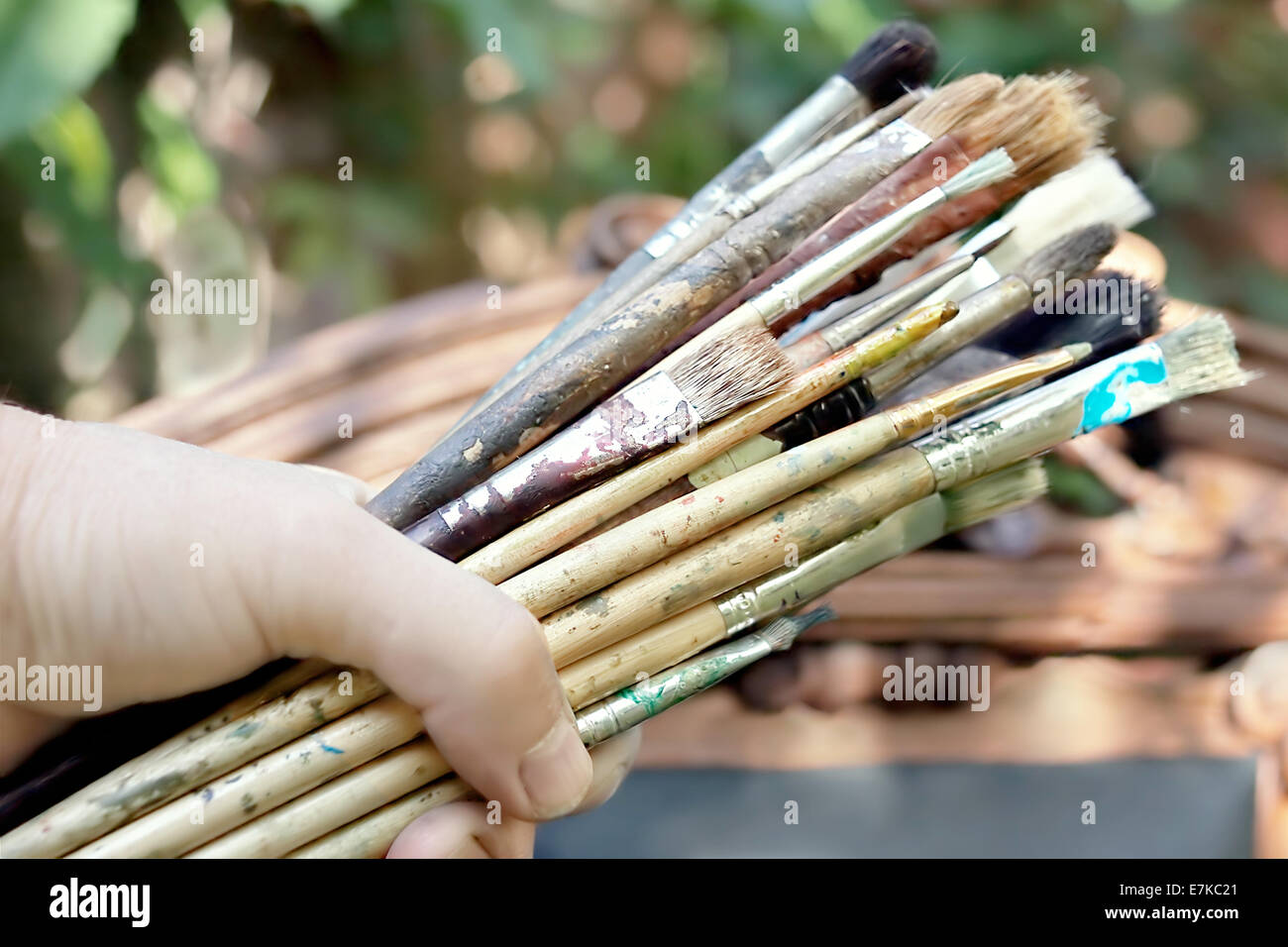 Artist hand holding paintbrushes Stock Photo - Alamy